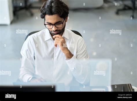 busy serious indian business man analyzing market data looking at
