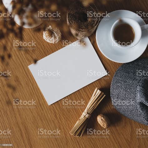 카페의 나무 테이블에 가을 정물 빈 종이 카드 커피 컵 여성 모자 꽃병에 마른 잔디 우아한 여성스러운 업무 공간 아늑한 홈