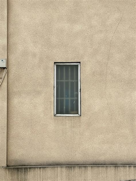 A Small Barred Window Is Set In A Tan Wall Photo Free Building Image On Unsplash