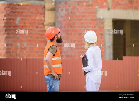 Construction Industry Concept Woman Engineer And Bearded Brutal Builder Discuss Construction