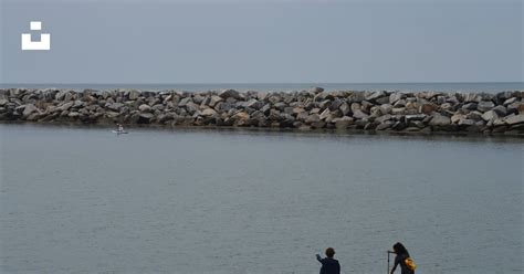 검은 잠수복을 입은 남자와 여자가 낮에 물속에서 노란 서핑 보드를 타고 있습니다 사진 Unsplash의 무료 바닷가 이미지