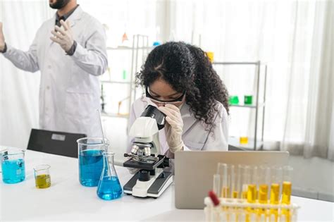 Premium Photo Lab Worker Using Magnifying Glass On Microscope