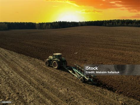 밭에서 쟁기를 가진 트랙터 일몰에 녹색 트랙터 쟁기질 필드 건초 식물에 대한 스톡 사진 및 기타 이미지 건초 식물 경관 경작지 Istock