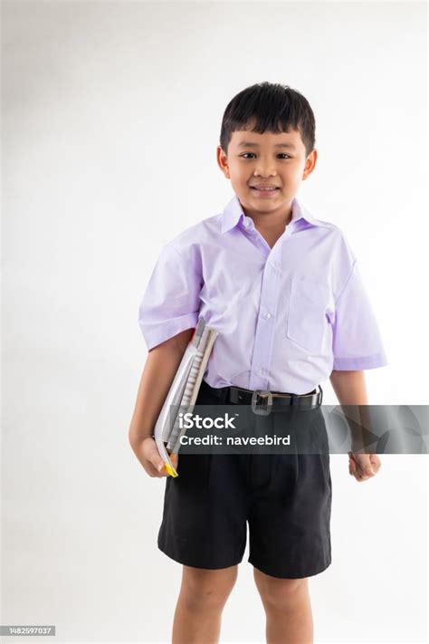 책을 들고 있습니다 배낭 가방이 있는 태국 교복 젊은 아시아인은 하얀 배경 배너에 서 있는 귀여운 소년을 흥분시킨다 학교로 돌아 가기 6 7 살에 대한 스톡 사진 및 기타