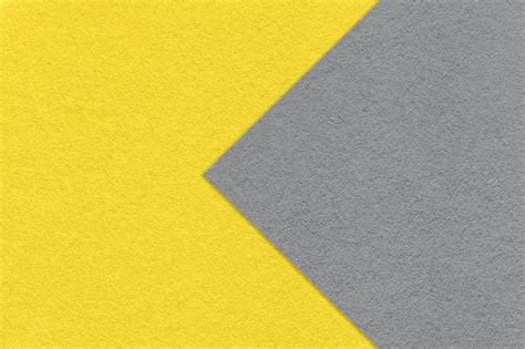 회색 화살표 매크로가 있는 노란색 종이 배경 절반의 질감 고밀도 공예 판지의 구조 프리미엄 사진