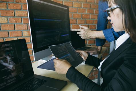 Two Software Developers Are Analyzing Together About The Code Written