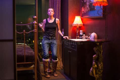 A Young Girl In Jeans And Boots With A Glass In Stock Image Image Of