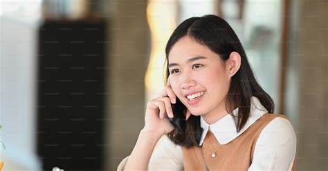 현대 카페에 앉아 있는 동안 휴대 전화로 이야기하는 젊은 여성의 초상화 사진 Unsplash의 태국 이미지