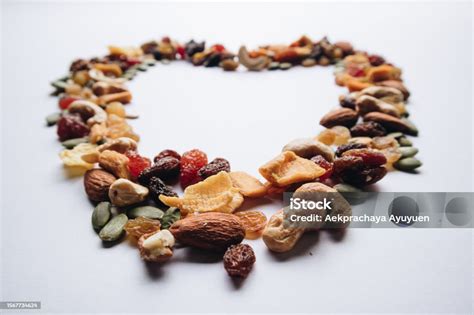 다양한 종류의 건강에 좋은 곡물과 말린 과일이 흰색 배경에 텍스트나 이미지를 위한 빈 공간이 있는 하트 모양으로 배열되어 있습니다 건강한 음식과 체중 감량 건강한 간식