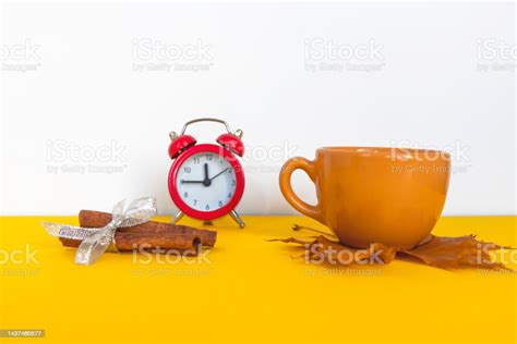 노란색 세라믹 커피 컵과 계피는 가을 단풍 잎이 있는 알람 시계의 배경에 붙어 있습니다 추운 계절의 시작의 개념 0명에 대한 스톡 사진 및 기타 이미지 Istock