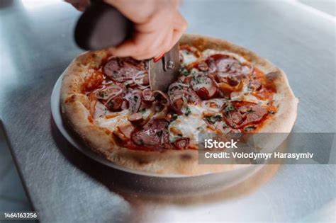 한 남자가 피자를 조각으로 자른다 부엌에서 피자를 자르는 흰색 유니폼을 입은 요리사 제빵사의 근접 촬영 손 기술에 대한 스톡 사진 및 기타 이미지 Istock