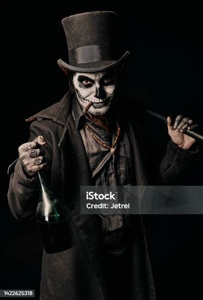부두교 신인 남작 사메디의 모습을 띠고 있는 청년 토요일 검은 코트와 술 한 병과 손에 붙어있는 모자를 쓴 남작 죽은 자의 날 테마 남자에 대한 스톡 사진 및 기타 이미지