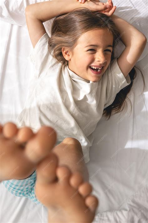 Ein Süßes Kleines Mädchen Liegt Morgens Im Bett Und Lächelt Premium Foto