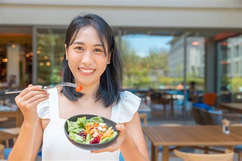 아침 식사를 먹고 스마트 폰을 즐기는 여성 수박 파파야 멜론 열정 과일 오렌지 주스 및 커피와 같은 과일 회색 플레이스매트 위에