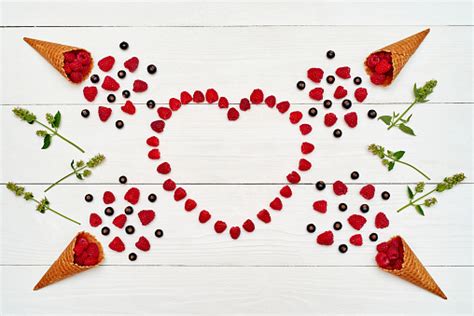 심장 모양 의 상징 여유 공간 달콤한 라즈베리 흰색 배경에 와플 콘에 라즈베리와 검은 건포도 건강한 음식 여름 개념 플랫 레이