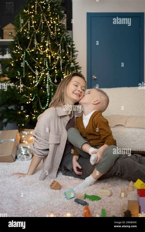 Smiling Mother Receiving A Sweet Kiss On The Cheek From Her Son While