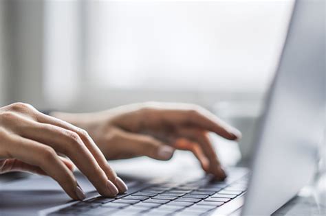 이 이미지는 여성의 손을 세밀하게 포착하여 세련된 노트북 키보드로 타이핑하고 배경에는 흐릿한 사무실 설정이 있습니다 검색에 대한 스톡 사진 및 기타 이미지 Istock