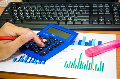 premium photo close up of hand using calculator while analyzing graph