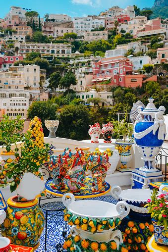 레몬 모티브와 장식용 꽃병이 있는 다채로운 이탈리아 전통 도자기가 이탈리아 포지타노에 전시되어 있습니다 지중해 도자기 수공예 예술품 야외 시장의 활기찬 식기 여행과 문화
