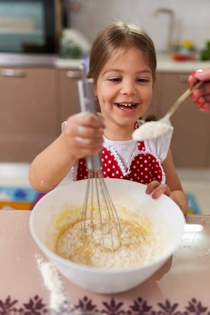 Niña ayudando a su madre en la cocina Foto Premium