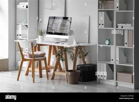 Interior Of Stylish Office With Programmers Workplace And Shelf Units