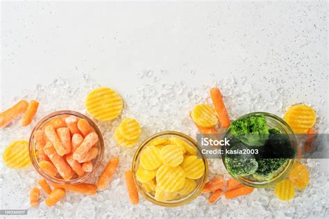 녹색 브로콜리 노란색 아기 당근 과 같은 냉동 채소는 얼음과 콘크리트 회색 배경에 유리 그릇에 복사 공간을 가지고 있습니다 개체 그룹에 대한 스톡 사진 및 기타 이미지