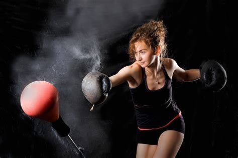 권투 장갑 권투 선수 여자 레드 샌드 백을 명 중 한다 킥복싱과 싸움 스포츠 개념입니다 어두운 배경입니다 텍스트 복사 공간에 대 한 공간입니다 가방에 대한 스톡 사진 및