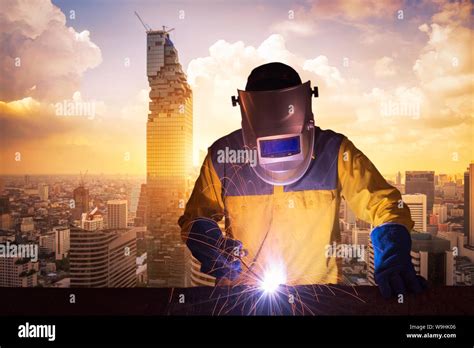 Welding Worker Welding Steel Structure With Modern Building In Big City