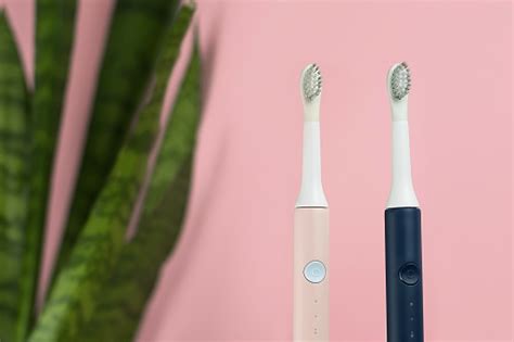 새로운 현대 초음파 칫솔 분홍색 파스텔 배경에 녹색 잎이있는 치과 진료 용품 구강 위생 잇몸 건강 건강한 치아 치과 제품 초음파