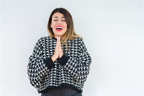 젊은 여자는 얼굴 매우 감정적이 고 걱정에 희망 식 함께 손으로 기도하 고 구걸 격리 된 배경 위에 캐주얼 스웨터를 입고 용 서에 대 한 요구 종교 개념입니다 감정에 대한