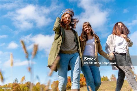 구름이 있는 푸른 하늘을 배경으로 녹색 잔디밭에서 달리는 세 명의 소녀 여자 친구 개념 자연에 대한 스톡 사진 및 기타 이미지 자연 단체 사진 이미지 Istock