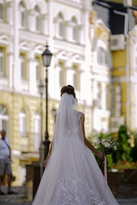 Premium Photo Caucasian Bride In A White Dress Walks Along The