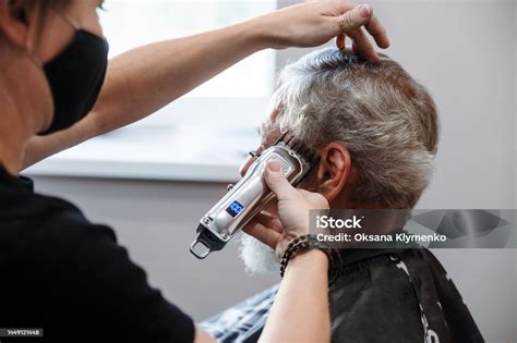 머리 깎기 작업 성숙한 수염 난 남자의 머리를 자르는 젊은 전문 이발사 소녀 그는 이발소에서 이발을 받고 있습니다 이발소 미용실 40 44세에 대한 스톡 사진 및 기타