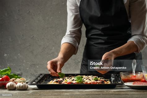 영양 개념입니다 전통 이탈리아 피자의 준비입니다 푸른 잔디 햄 햄 살라미와 햄 콘크리트 벽의 배경으로 완성 된 요리를 장식 하는 형태로 요리사 기술에 대한 스톡 사진 및