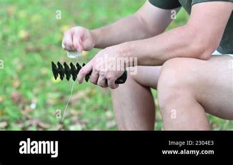 A Man Is Cleaning The Brush Cutter Attachment After Cutting Bushes Working With Garden Tools