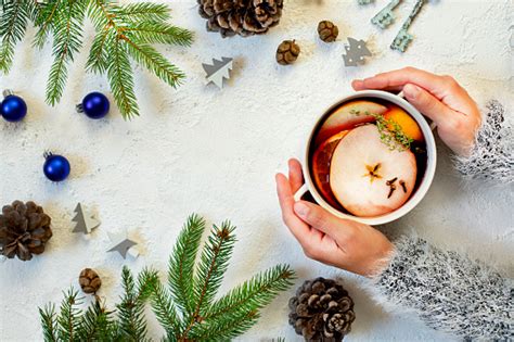 멀드 와인 한 잔을 들고 있는 여성의 손 레드 와인 시트러스 과일 및 향신료로 만든 따뜻한 음료 겨울 새해 크리스마스 장식 상단
