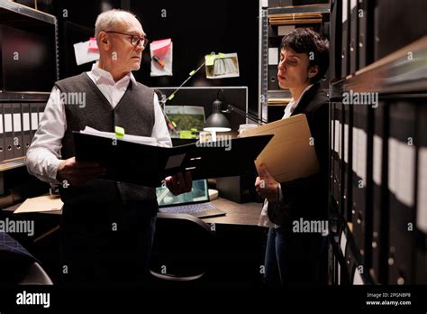 Private Detectives Discussing Missing Person Evidence Working Overtime At Mysterious Criminal