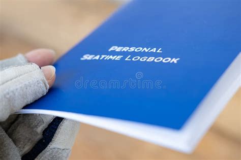 Gloved Hand Holding Blue Personal Seatime Logbook Maritime Record