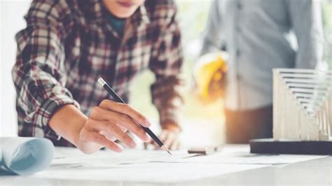 Premium Photo Midsection Of Female Architect Drawing Blueprint At Desk