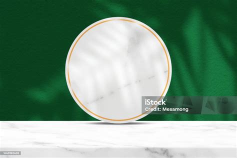 흰색 대리석 테이블과 원형 파티션 녹색 콘크리트 벽 질감 배경에 코코넛 잎 그림자가 있는 금색 가장자리 화장품 프레젠테이션 배경 디스플레이 및 모형에 적합합니다 강단에 대한