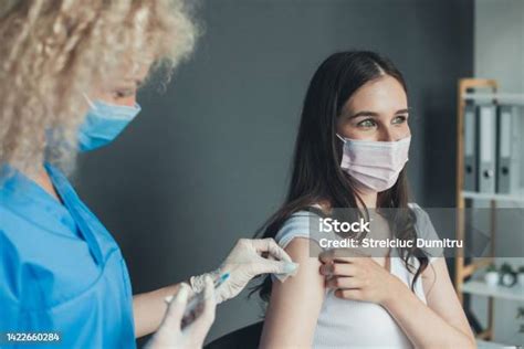 의료용 안면 마스크를 착용한 젊은 백인 여성이 병원에서 코로나19 백신을 맞고 있다 의료 의료 개념 전염병 예방 여성 건강 개념 20 24세에 대한 스톡 사진 및 기타