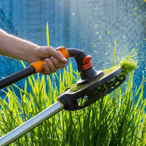 Premium Ai Image Hand Held Grass Trimmer Mowing Green Lawn Grass