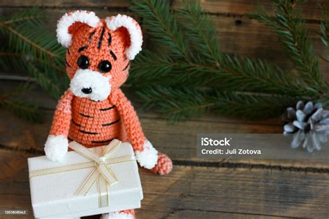 크로 셰 뜨개질 오렌지 호랑이는 선물과 나무 배경에 앉아 귀여운 눈으로 카메라를 보고 Diy 크리스마스 장식 2022 호랑이의 해 0명에 대한 스톡 사진 및 기타 이미지