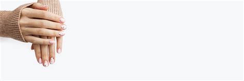 가벼운 배경에 파스텔 베이지 매니큐어 잘 손질 된 손톱과 부드러운 손 피부 살롱 배너 와 복사 공간 따뜻한 스웨터를 입은 여성의