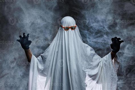Man In Scary Ghost Costume In Smoke On Grey Mysterious Background In