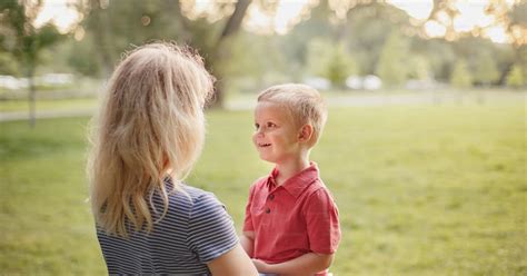 젊은 백인 어머니와 소년 유아 아들이 얼굴을 맞대고 함께 앉아 있습니다 가족 엄마와 아이는 여름날 야외에서 의사 소통을합니다 행복 한 정통 가족 어린 시절 생활 방식