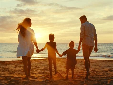 Картинка семья Счастливая семья стоящая на пляже во время заката