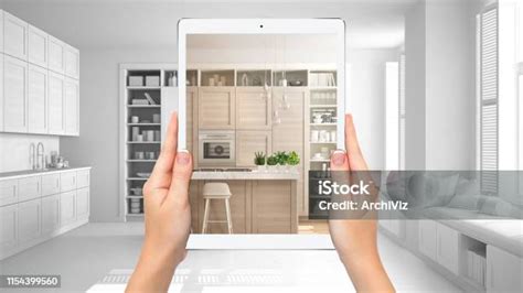 손을 잡고 현대 흰색과 나무 부엌을 보여주는 태블릿 총 빈 프로젝트 배경 증강 현실 개념 가구 및 인테리어 디자인 제품을