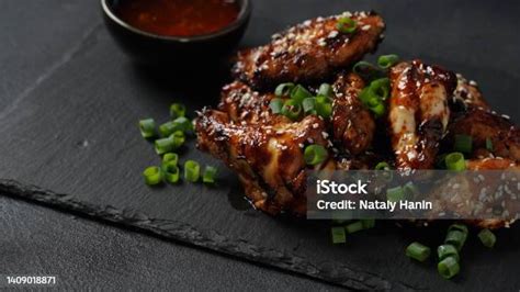 검은 돌 배경 위에 슬레이트 보드에 녹색 양파로 장식 된 소스와 함께 구운 닭 날개 고기에 대한 스톡 사진 및 기타 이미지 고기 슬레이트 0명 Istock