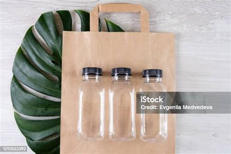 갈색 종이 에코 백에 3 개의 플라스틱 병 로고를 위한 장소 복사 공간이 있는 회색 배경에 친환경 식품 포장 및 면 에코 백 케이터링 및 길거리 패스트푸드용 용기 가방에